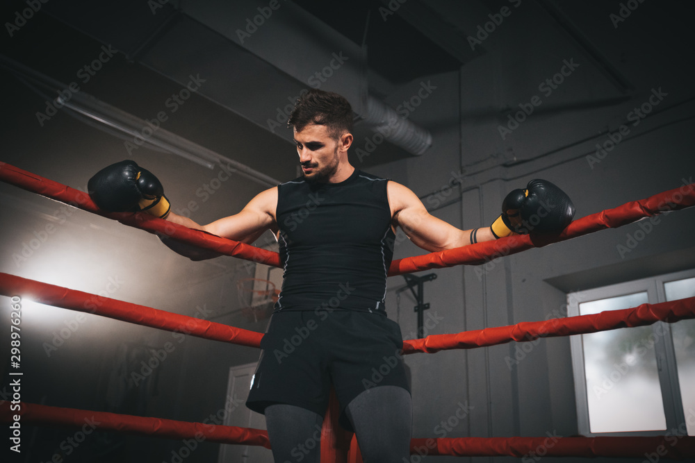 In a boxing ring athletic man have a break time after a boxing workout ...