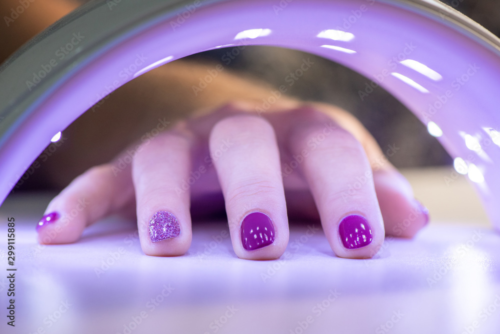 Close-up of the process of drying nails with gel polish in an ...