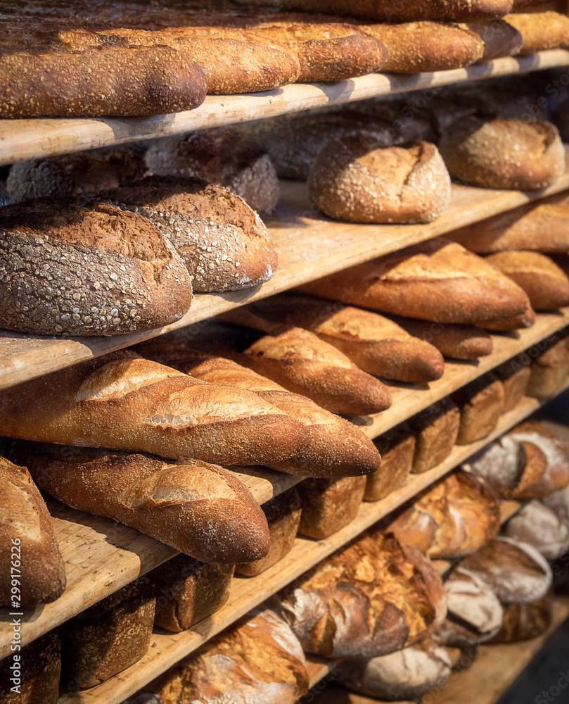 Round breads and long french loaves on shelves. Baked goods. Stock ...