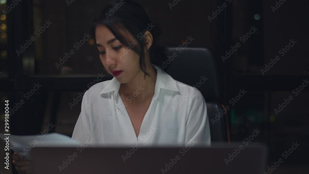 Millennial young Chinese businesswoman work late night stress out with ...