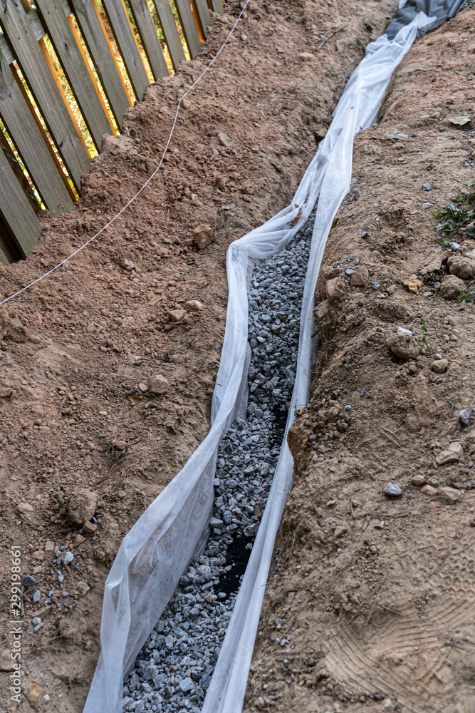 Drainage Rock in a French drain as part of a DIY home repair of ...