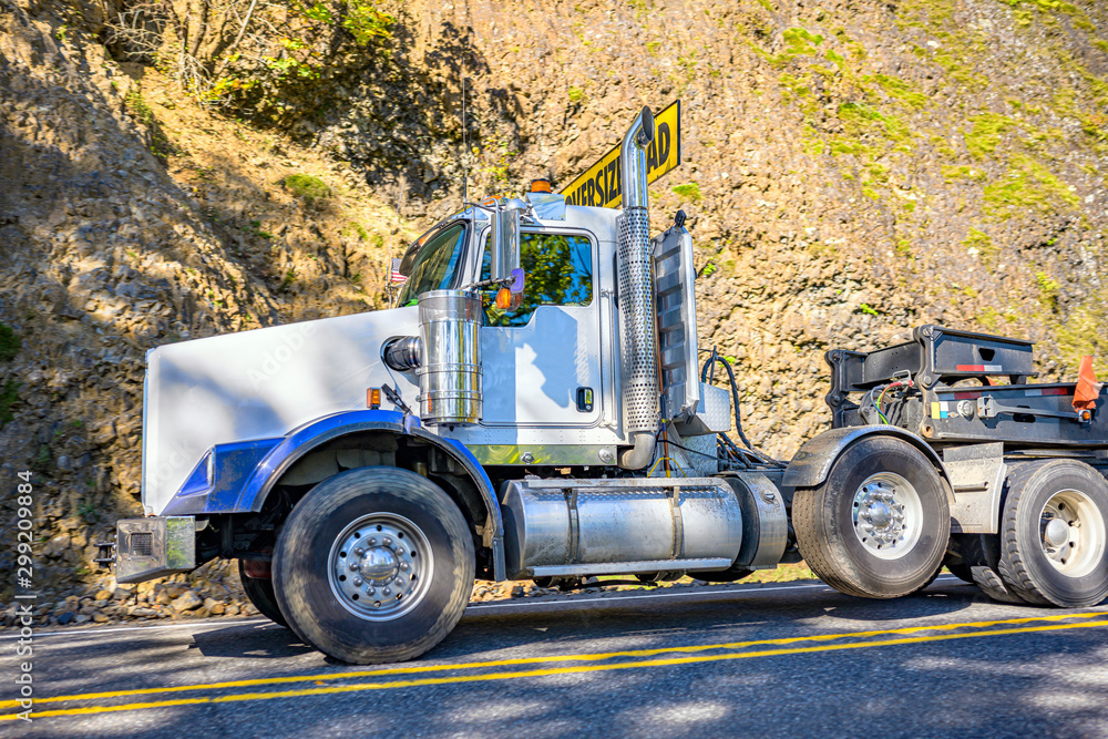 Profile of big rig powerful day cab semi truck with oversize load sign ...