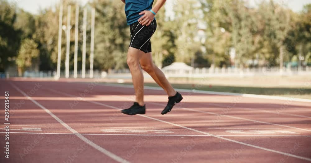 Asian male athlete doing warming up on stadium track before training ...