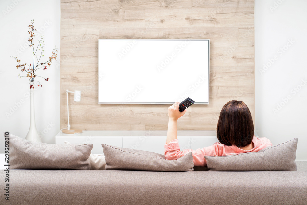 Back view of beautiful young woman resting in apartment, sitting on ...