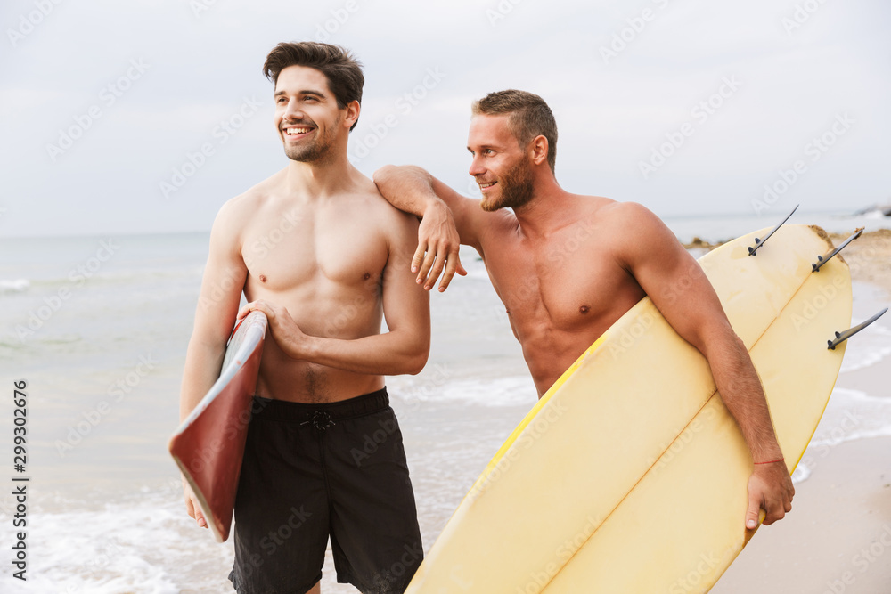 Positive two men surfers friends with surfings on a beach Stock Photo ...