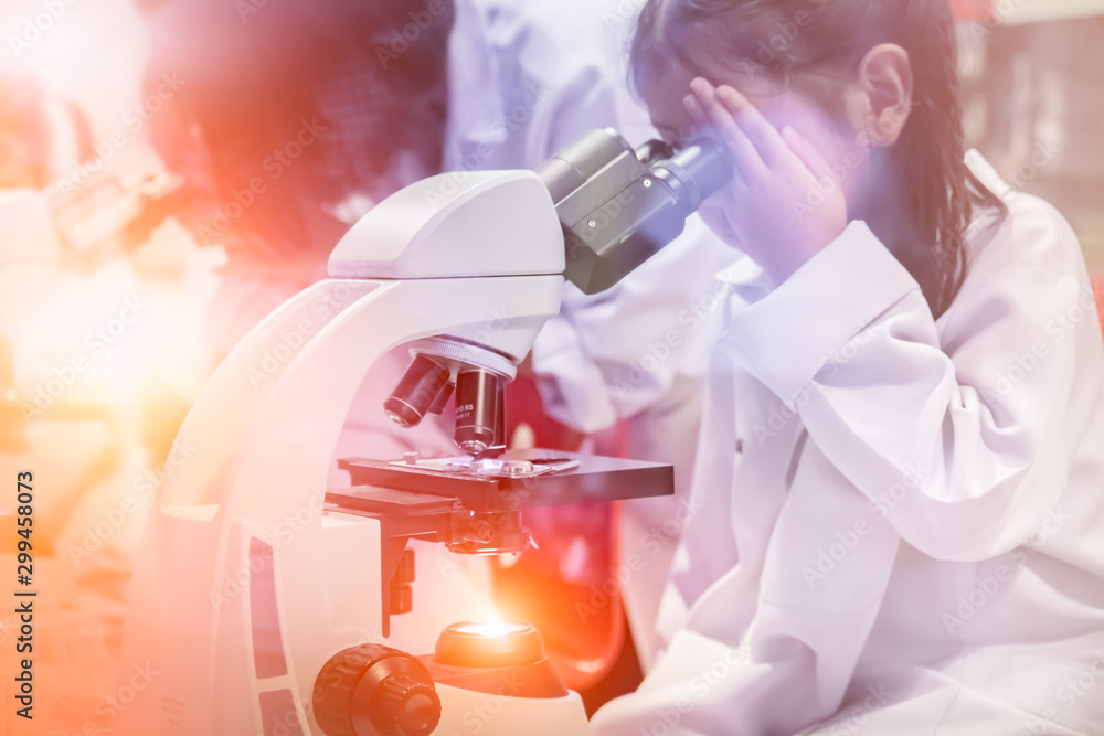 Cute little girl looking through a microscope. Science for children ...