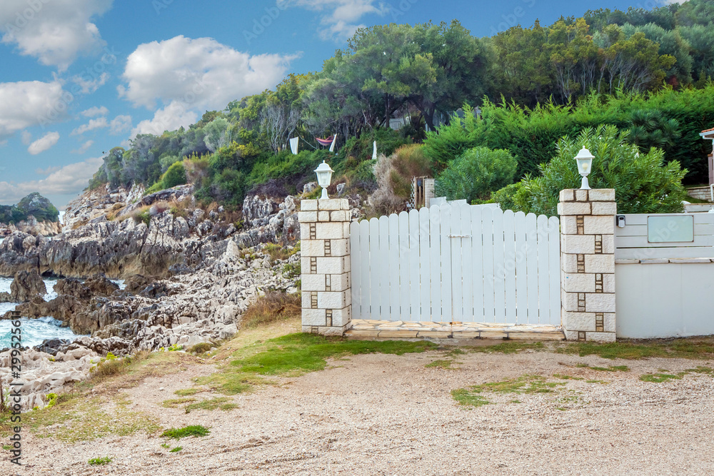 Beautiful white gate set above sea. Entrance to the courtyard. Corfu ...