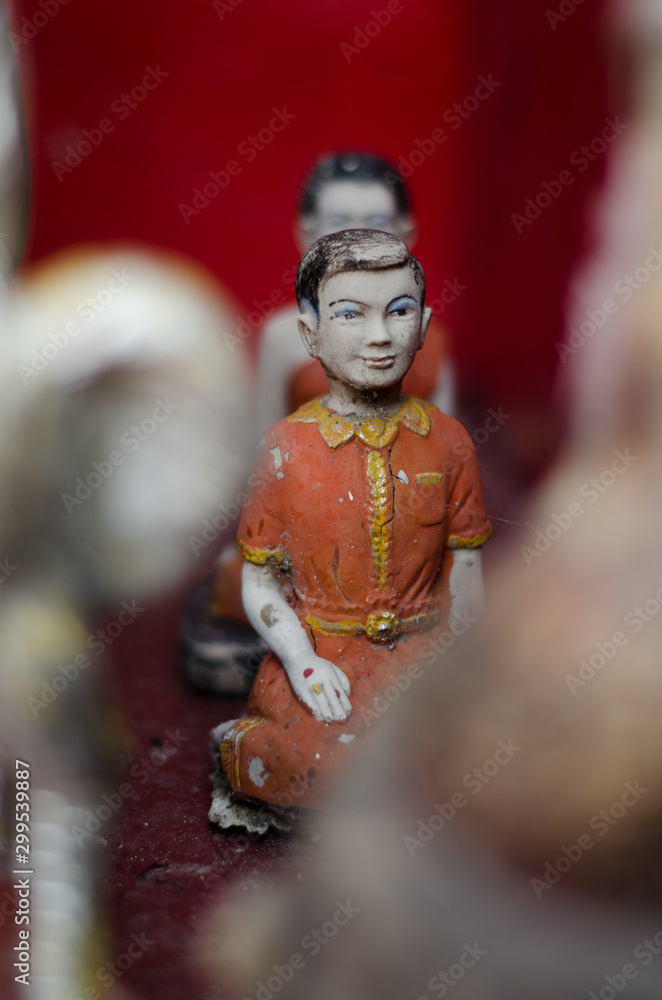 Buddhist devotee doll in red costume in a meditative posture inside a ...