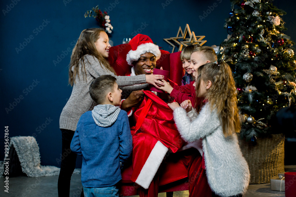 Five children look into the bag of African Santa Claus and laughing ...