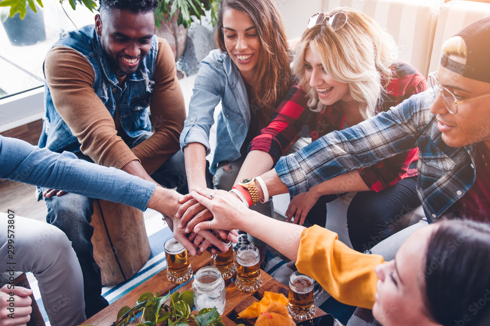 Group of mixed friends with stack of hands showing unity and teamwork ...