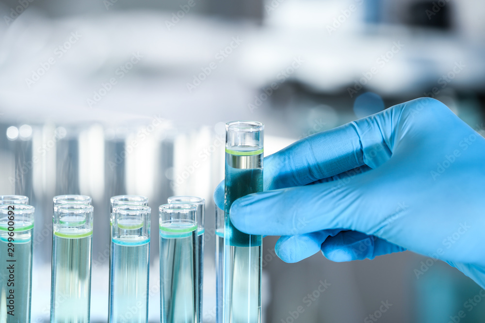 Doctor holding test tube with sample for analysis in laboratory ...