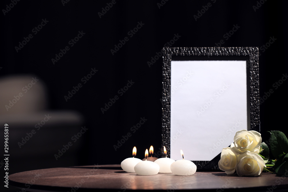 Funeral photo frame with black ribbon, roses and candles on wooden ...