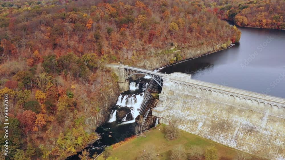 aerial dolly in to the waterfalls & dam wall. Then camera tilts down ...