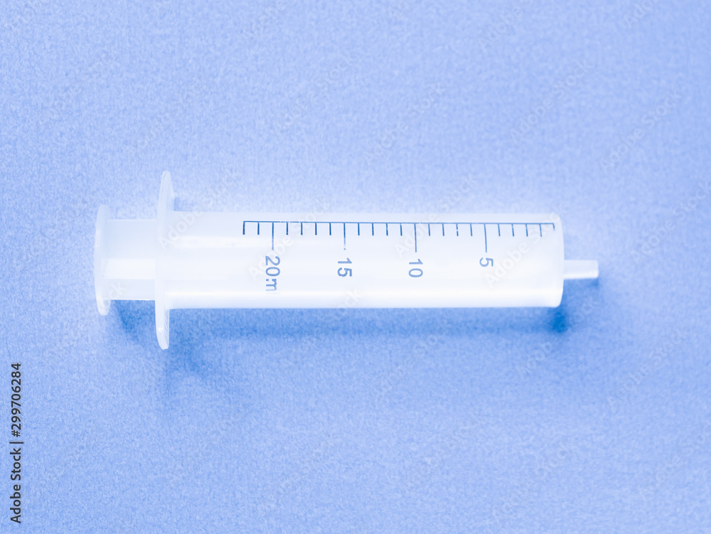 White syringe on a blue background. Syringe on blue background. 5ml ...