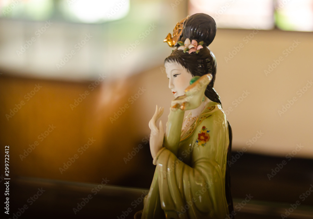 Side view of the statue of a Chinese goddess with braided hair and ...