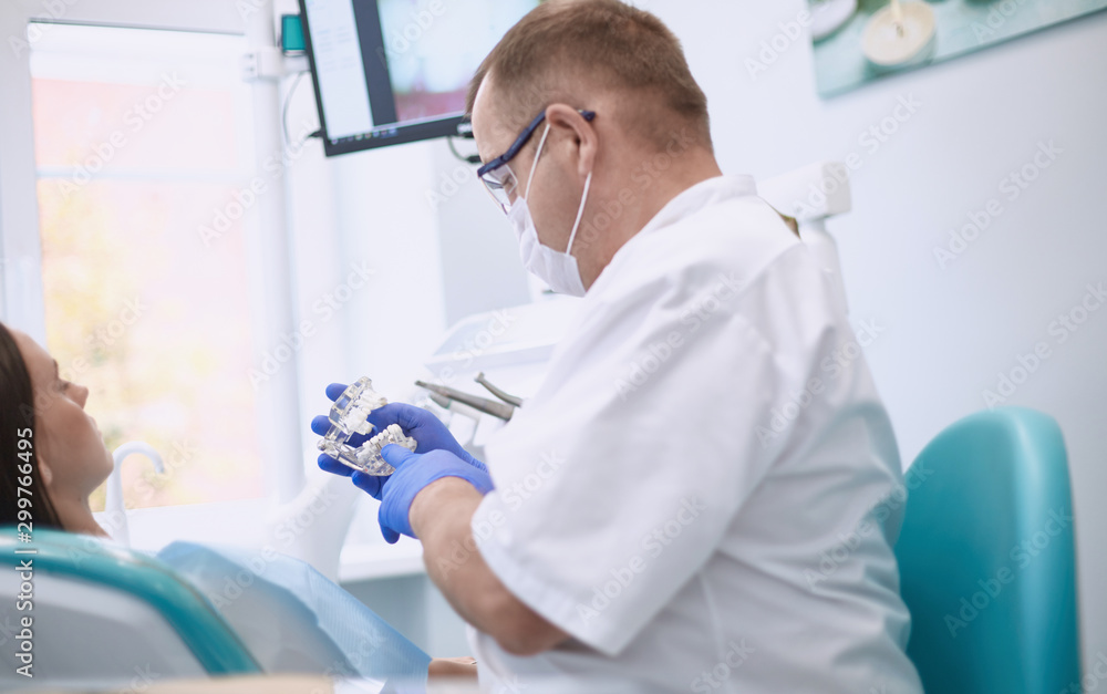 Doctor dentist treats teeth of a beautiful young girl patient. The girl ...