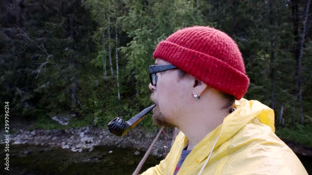 Man Smoking out of tube in nature. Stock footage. Man with beard and ...