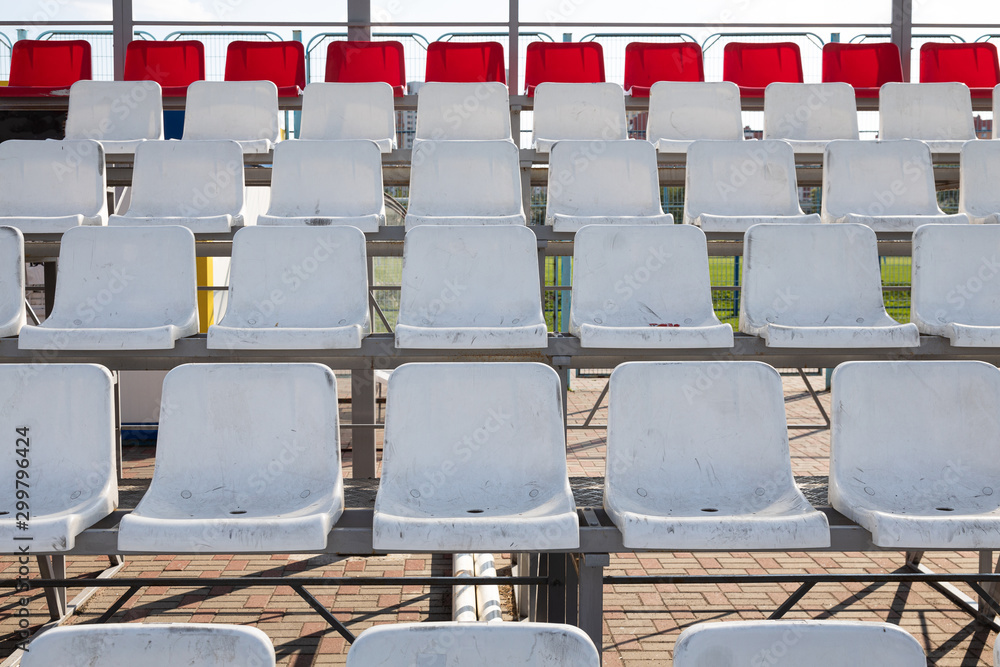 Front view of dirty white and red plactic seats on sport stadium's ...