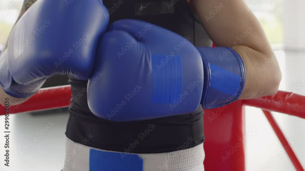 Tilt up close up shot of unrecognizable female athlete in boxing gloves ...