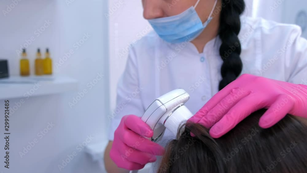 Trichologist examines woman patient's hairs using computer trichoscopy ...