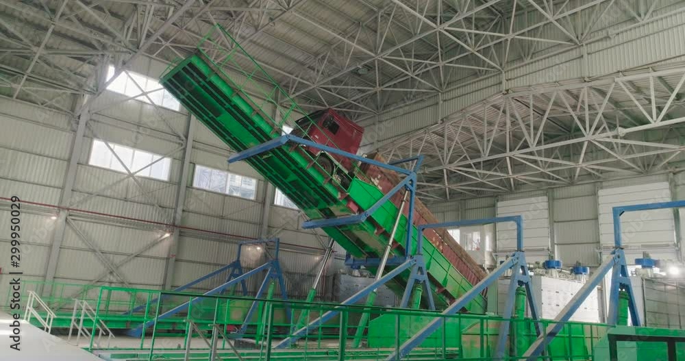 A truck is lifted on a platform for unloading grain. Unloading wheat ...