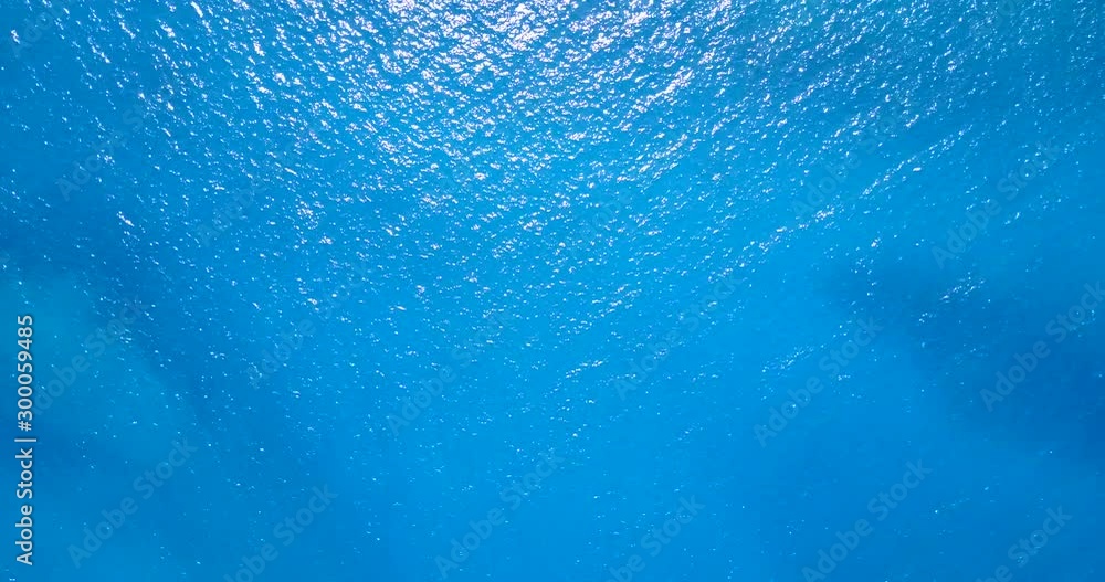 beautiful azure water texture with sun reflection on the left side. The ...