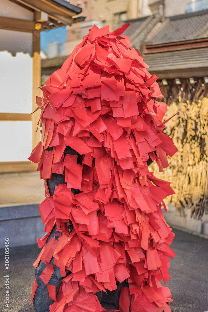 Statue of the Buddhist deity Akagami Nio covered with red papers ...