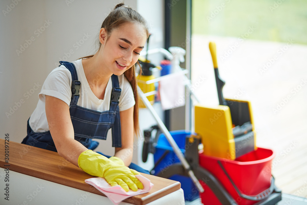 Positive caucasian girl in special equipment for cleaning carefully ...