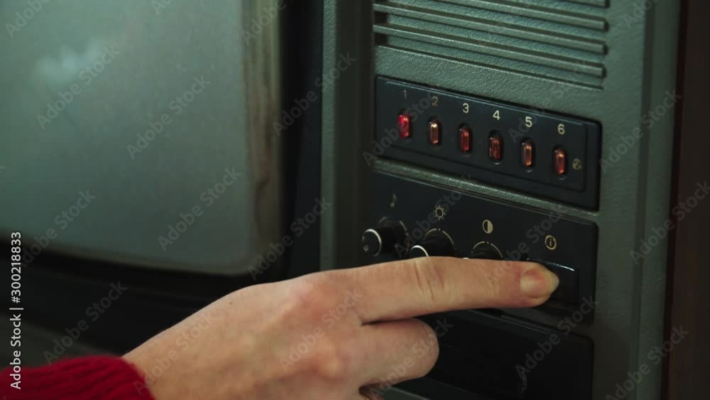 Close up of a vintage tv being turned off. Hand pushes a button and ...