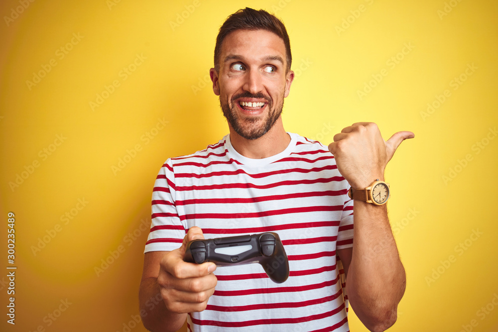 Young handsome man playing video games using joystick game pad over ...