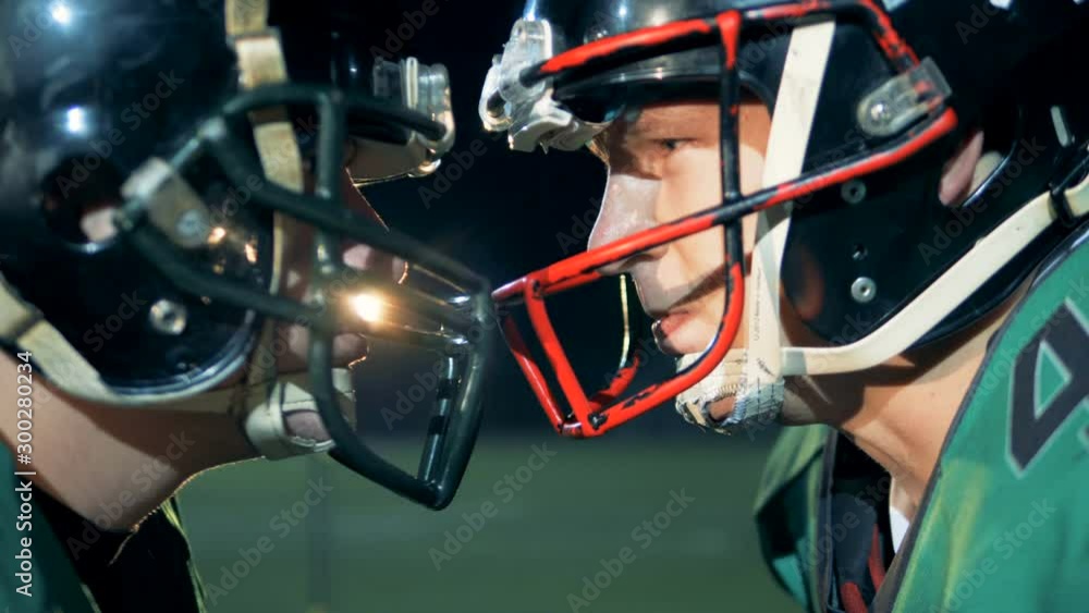 American football players, athletes stand head to head, side view ...