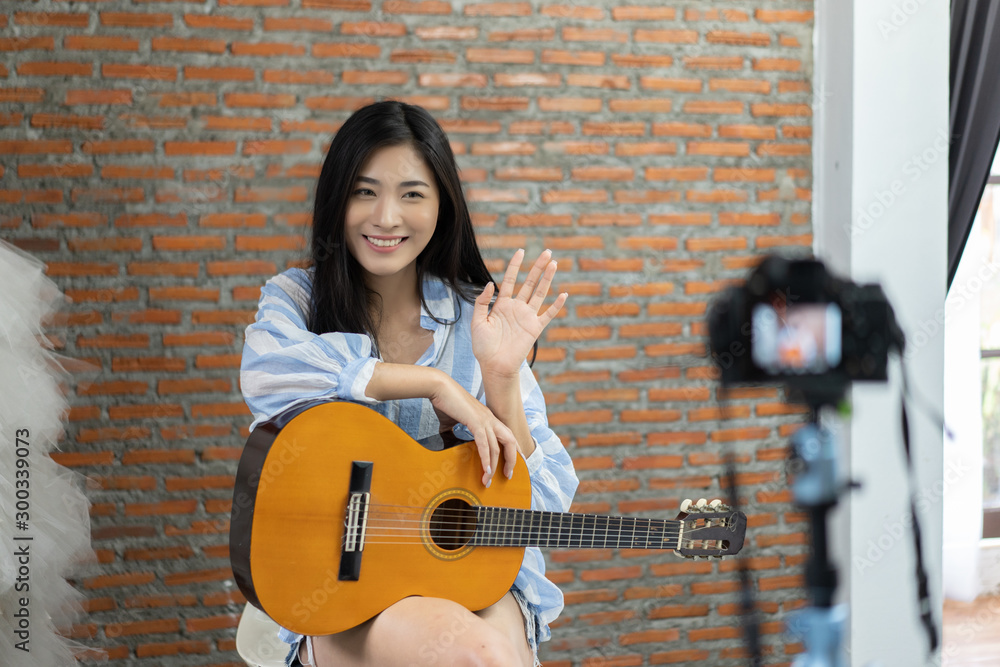 Attractive emotional smiling Asian Thai woman singing and playing ...