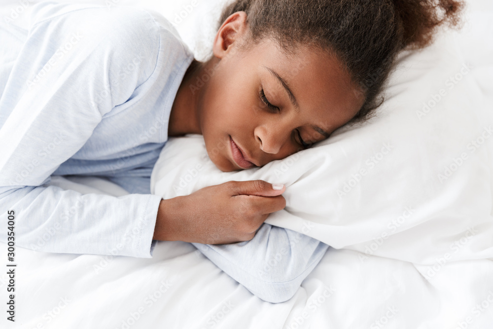 Image of peaceful african american little girl sleeping in bed at home ...