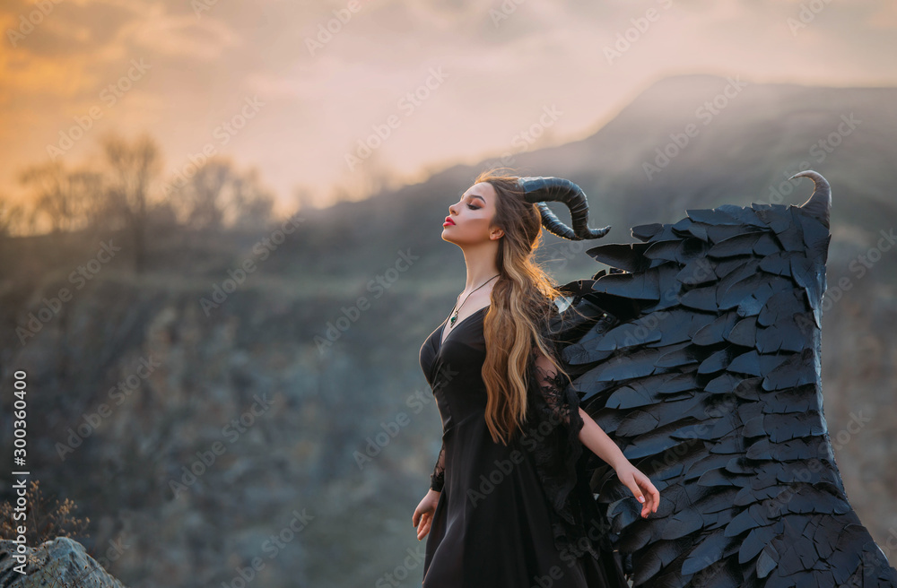 Fantasy lady in a black dress with huge wings. Demon with horns. Dark ...