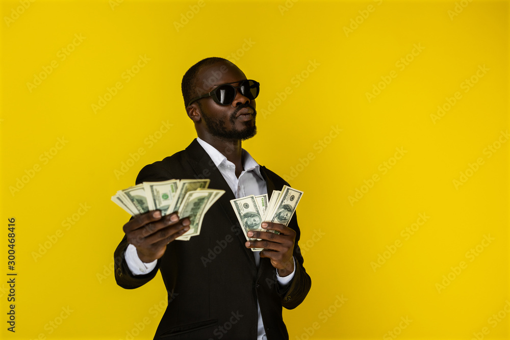 Serious and cool afroamerican guy shows the money Stock Photo | Adobe Stock
