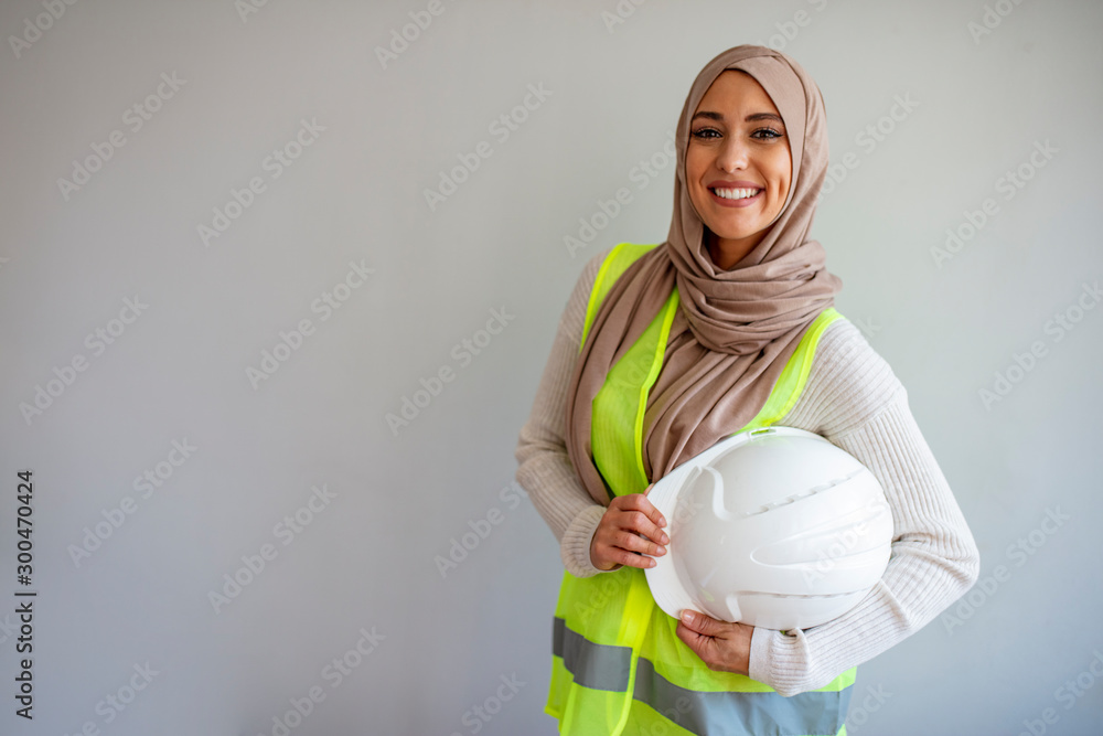 Pretty young Muslim woman smile while hold the plans with complete ...