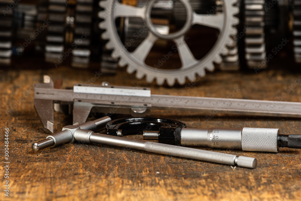 vernier callipers, micrometer and bore gauge on a workbench with gears ...