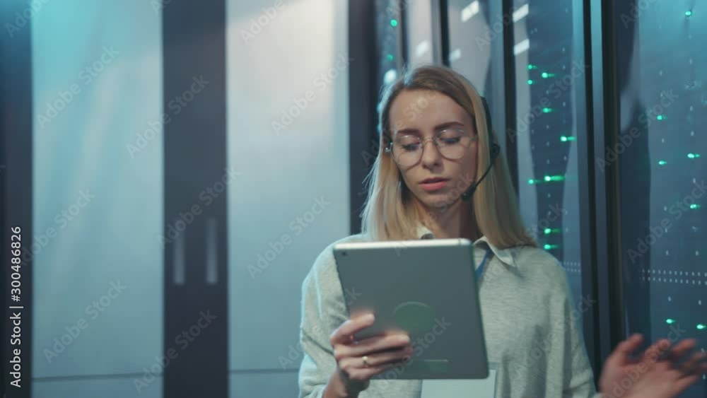 Young woman server administrator using digital tablet updating network ...