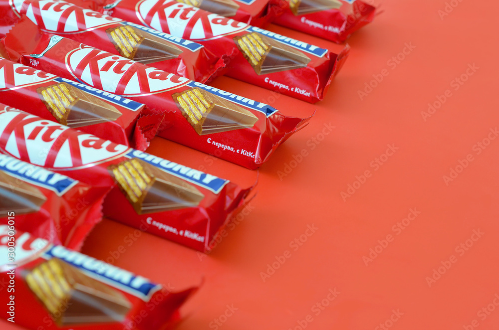 Kit Kat chocolate bars in red wrapping lies on yellow background is now ...