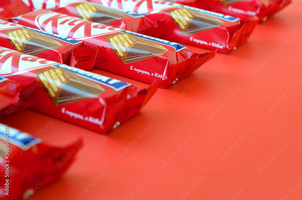 Kit Kat chocolate bars in red wrapping lies on yellow background is now ...