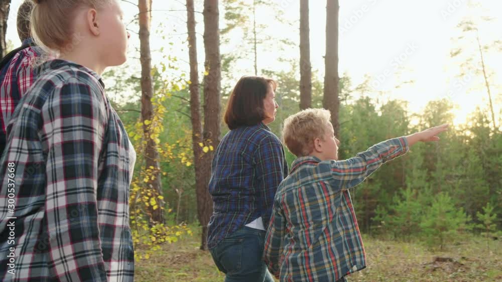 Family with two children walking in beautiful forest. Side view of ...