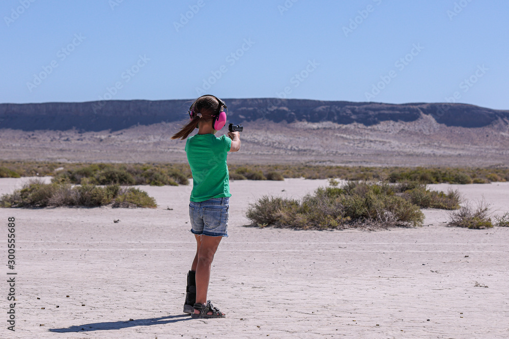 Little girl practicing target shooting with 22LR caliber pistol in ...