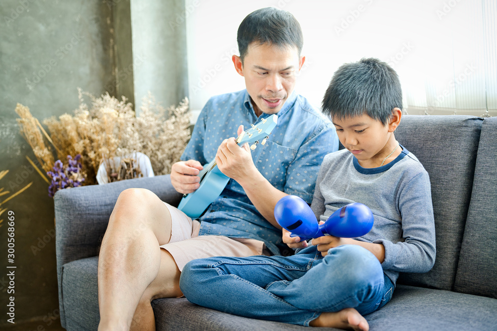 Asian Family making music at home with father, daughter and son playing ...