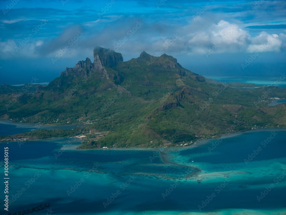 Panoramic aerial view of Vaitape, blue lagoon, white sandy beach and ...