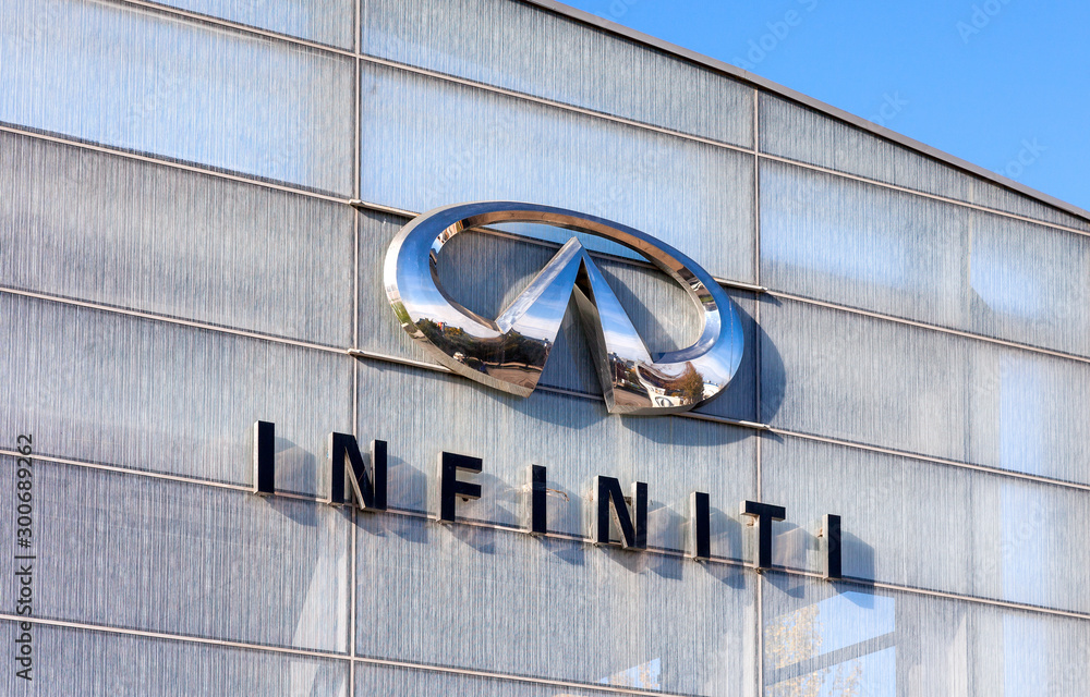 The emblem INFINITI on blue sky background. Infiniti is the luxury ...