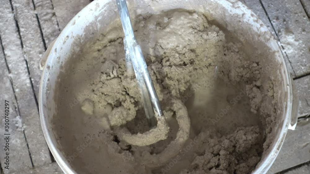 Builder builder fills water into dry construction mixture in bucket and ...