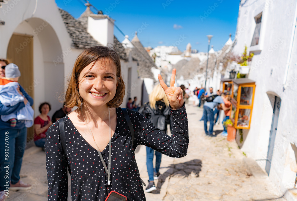 tourist girl happy in the narrow streets of Alberobello, famous town ...