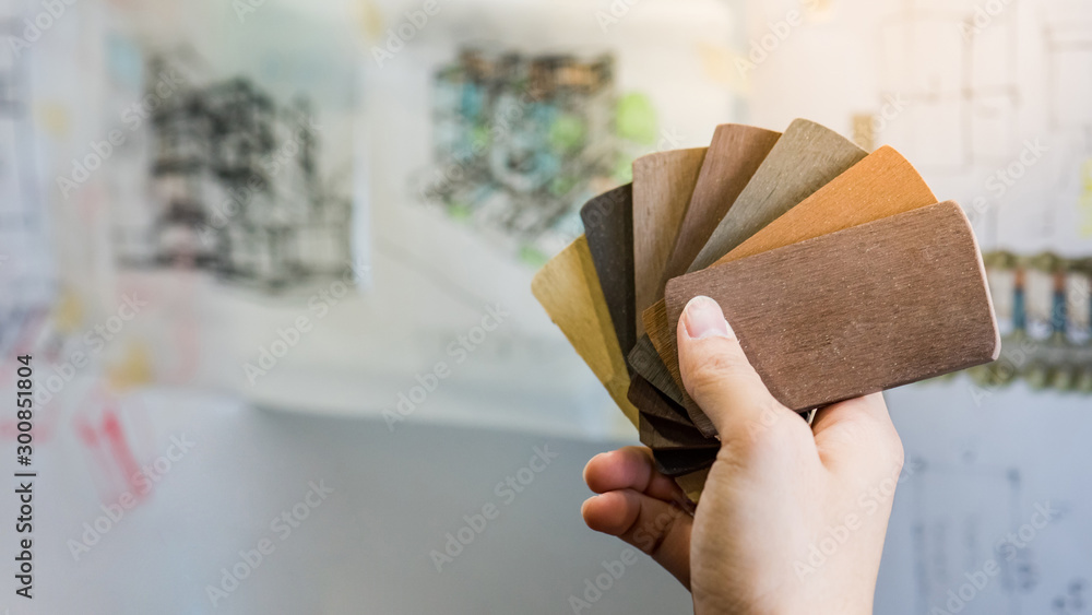 Male architect or interior designer hand holding wooden color swatch ...