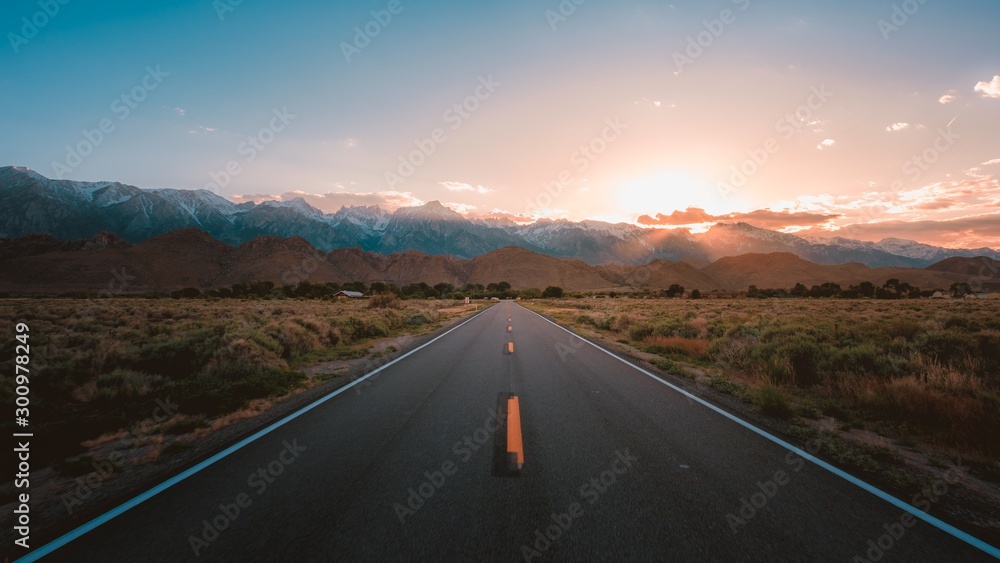 Straight road in the middle of the desert with magnificent mountains ...