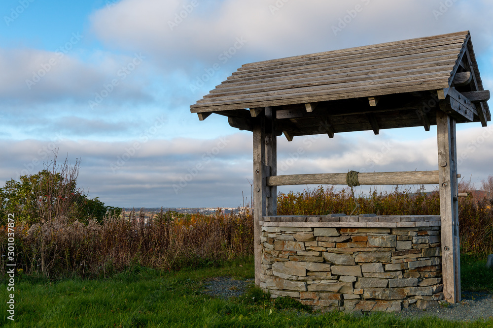 Water well made of rock and wood. The base is made of small rocks. The ...